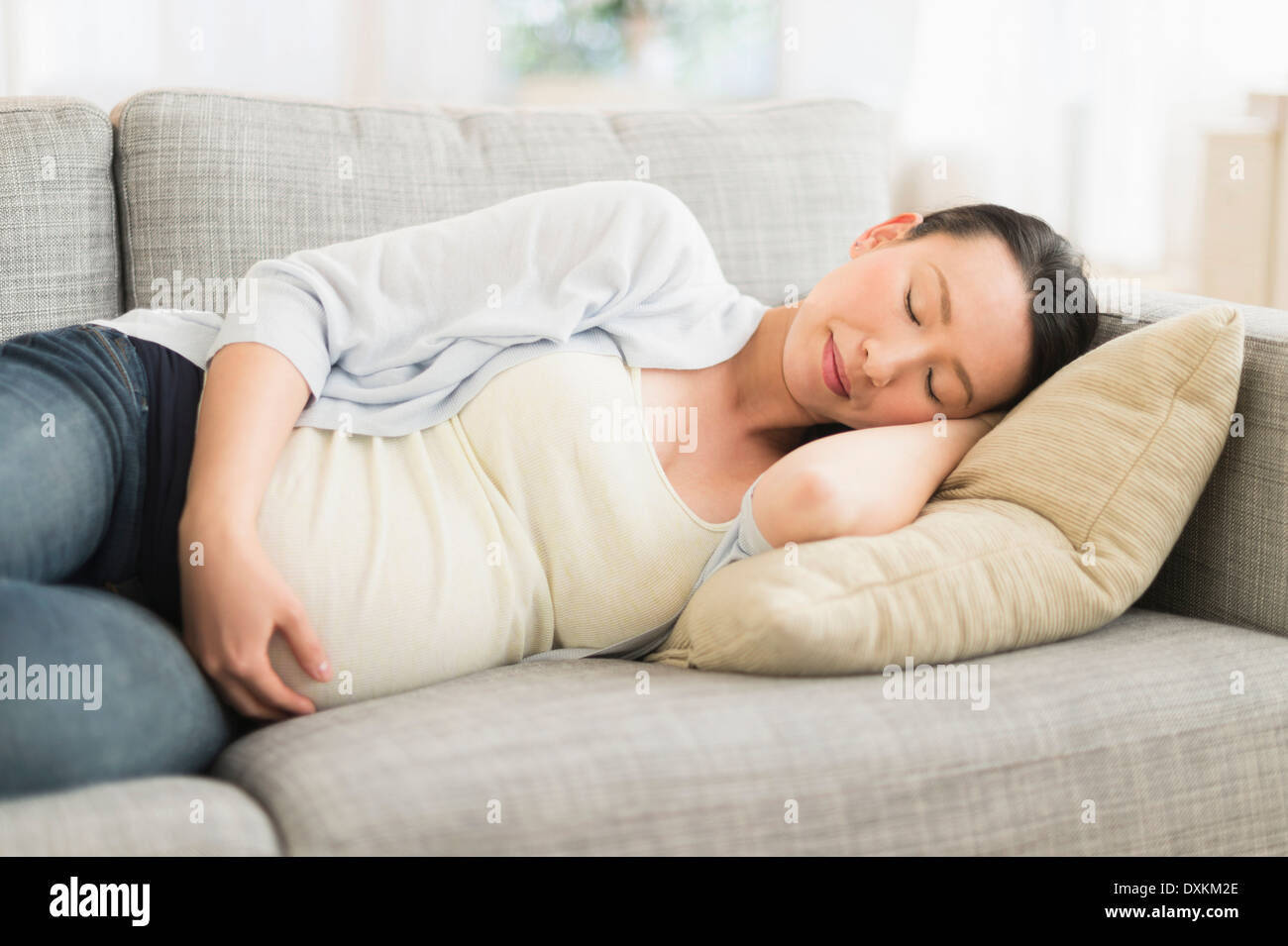 Pregnant Japanese woman napping on sofa Stock Photo - Alamy