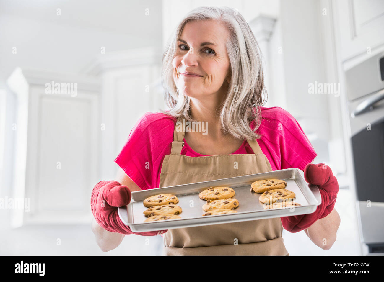 Woman holding baking tray of cookies hi-res stock photography and ...