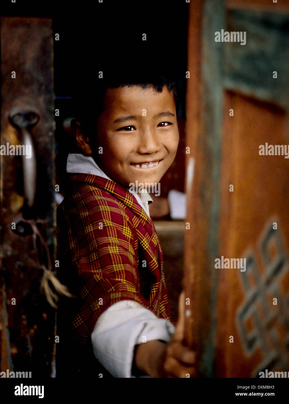 Young boy opening painted window shutters in Thimpu, Bhutan. Digitally ...