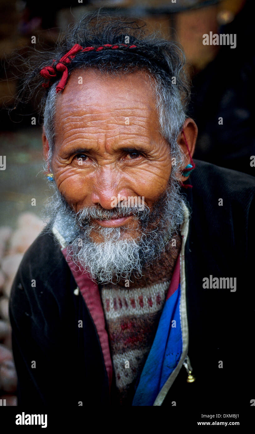 Bearded Bhutanese man with red ribbon bow in his hair in Thimpu market ...