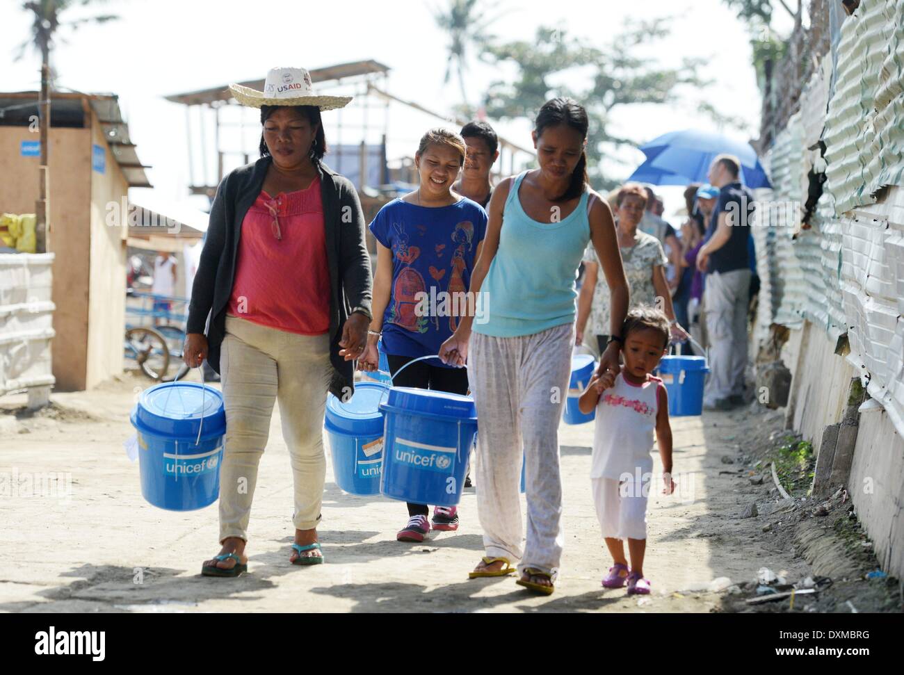 People carry buckets from the aid organization Unicef in which are ...
