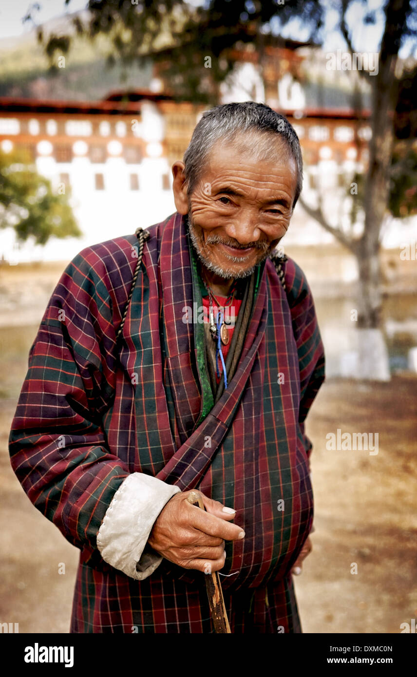 Elderly Bhutanses man in national dress in front of Punakha Dzong ...