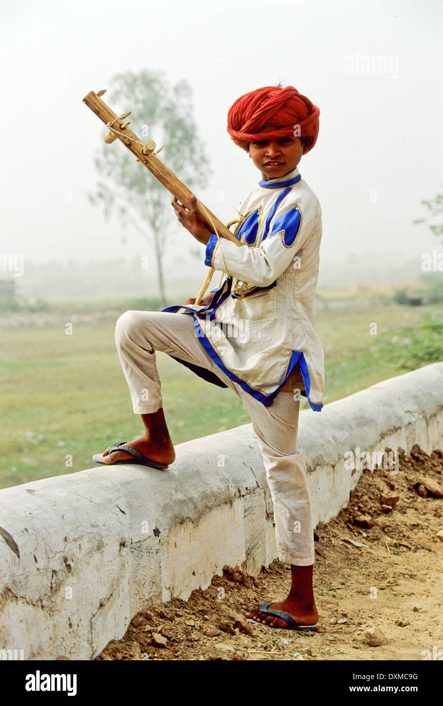 Indian musician with red turban playing stringed instrument Stock Photo ...