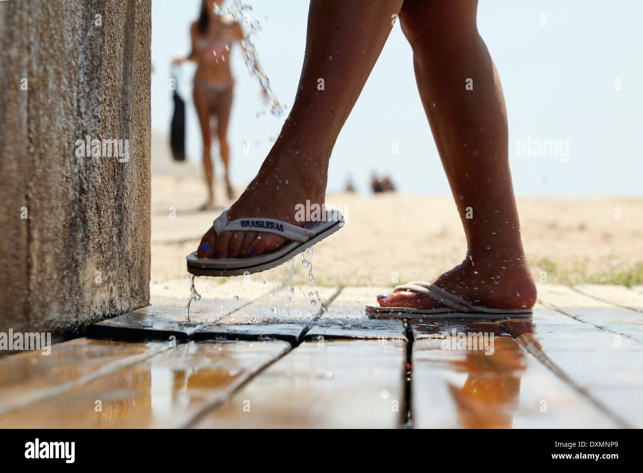 People remove sand off their feet after a sunny beach day in the island ...