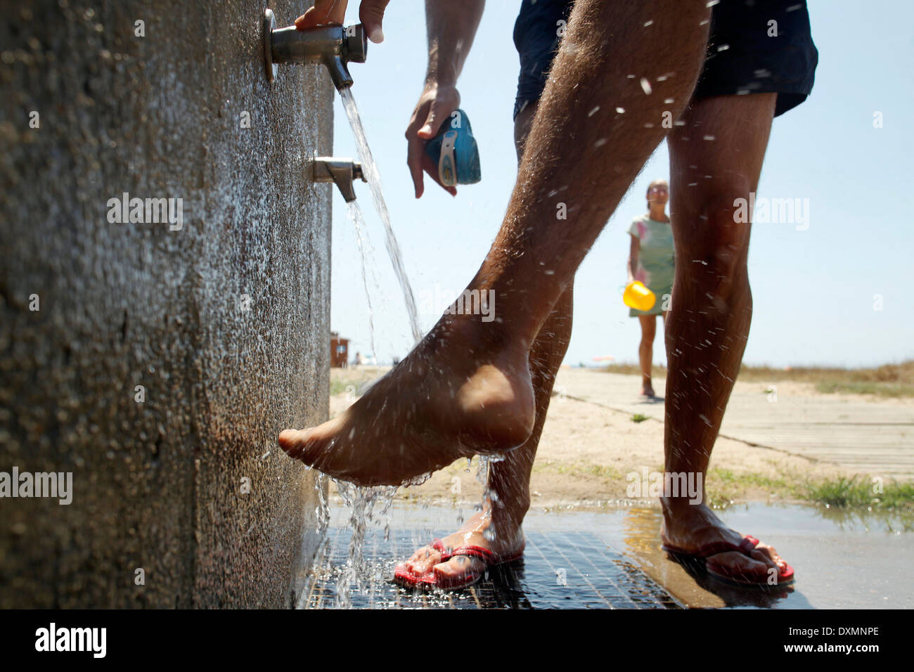 People remove sand off their feet after a sunny beach day in the island ...