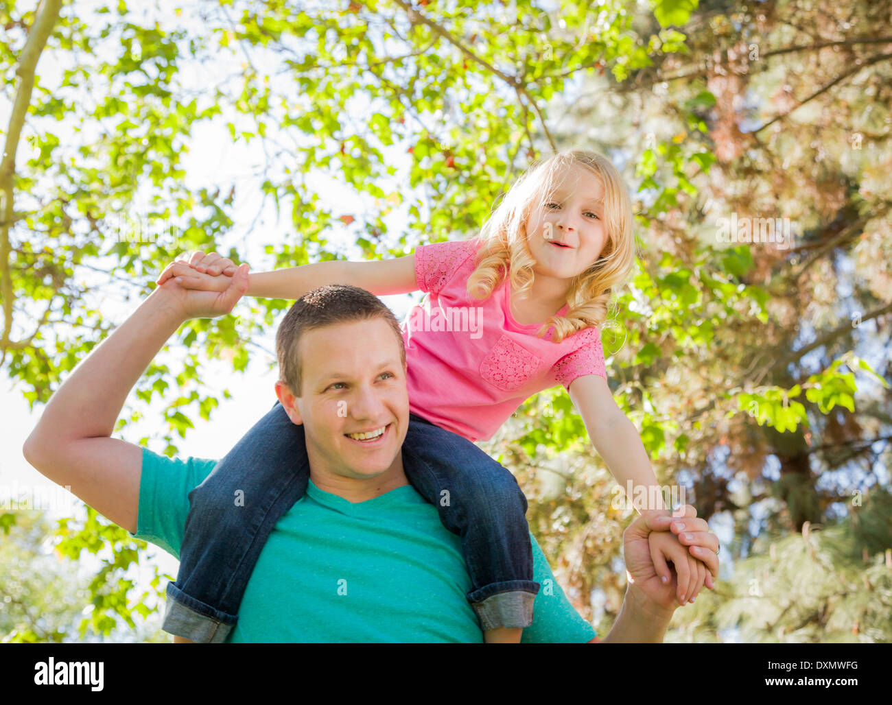 Cute Young Girl Rides Piggyback On Her Dads Shoulders Outside at the ...