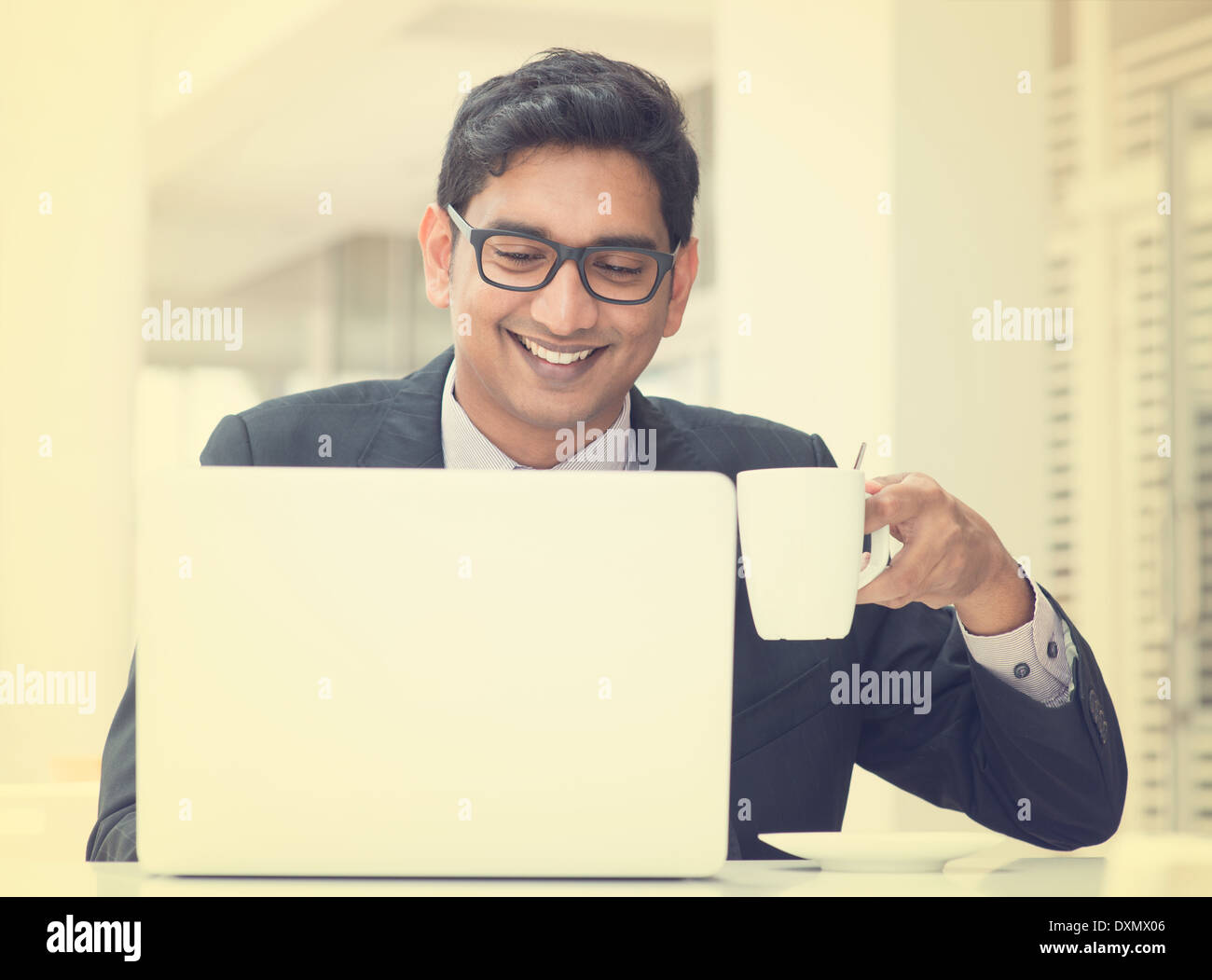 Young Asian Indian businessman using a notebook computer or laptop ...