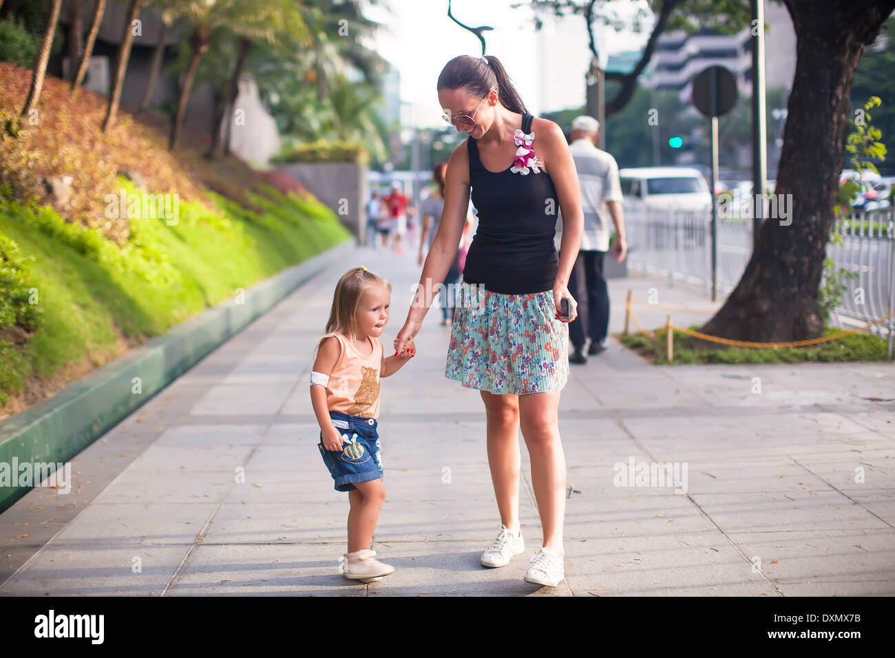 Young mother walking with little girl in a big city outdoor Stock Photo ...