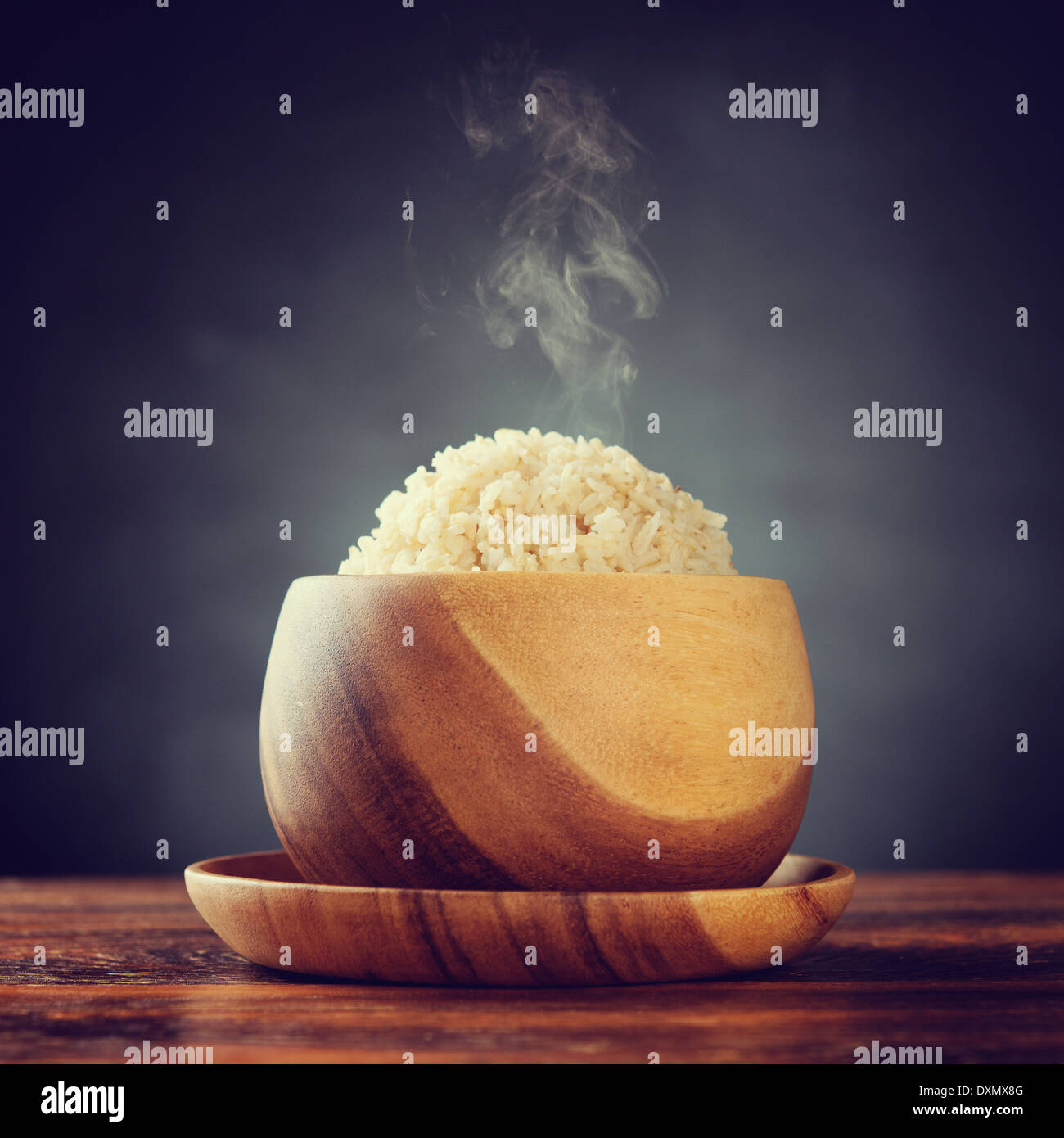 Cooked organic basmati brown rice in wooden bowl with hot steam smoke ...