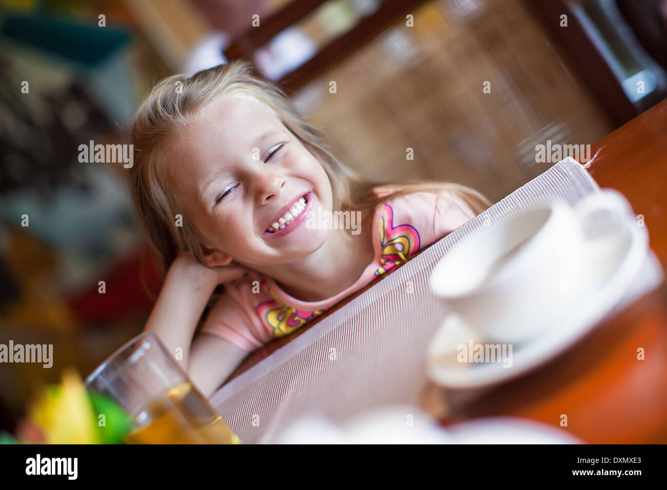 Smiling beautiful little girl having early breakfast Stock Photo - Alamy
