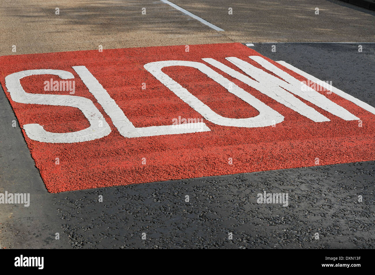 White lettering on red background reading SLOW in large letters on road ...