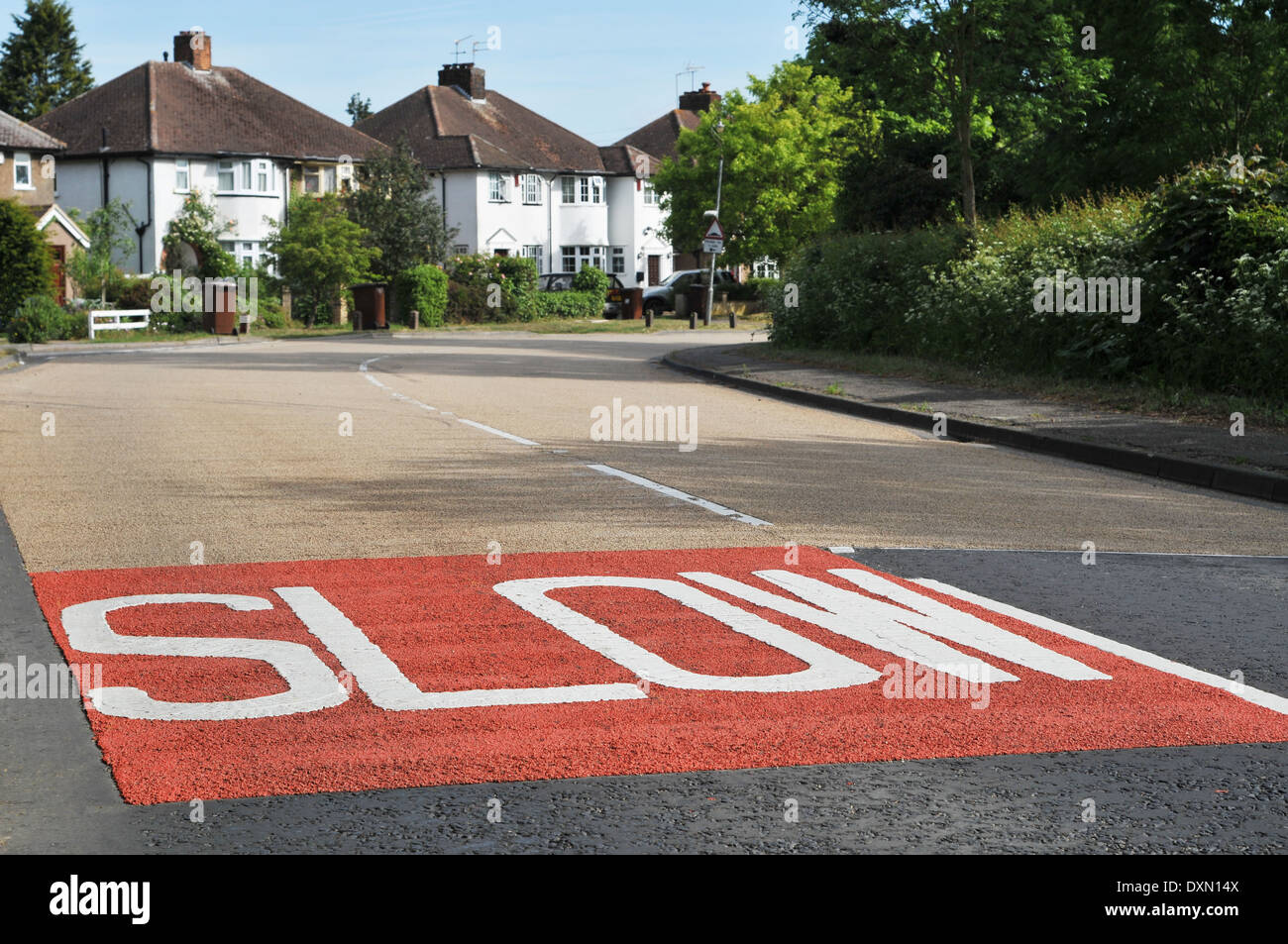 Residential road with the word SLOW in large white lettering with a red ...
