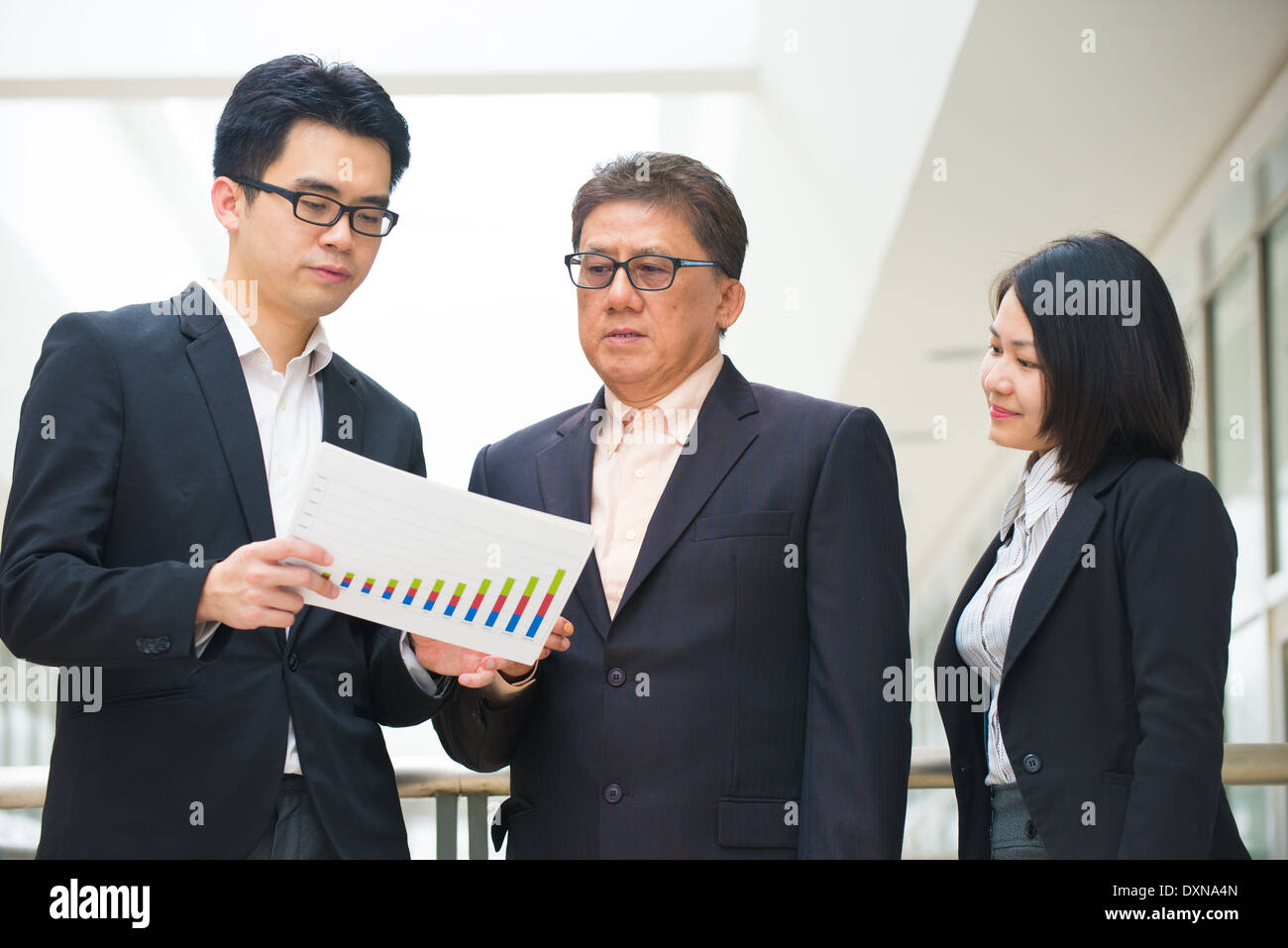 asian business team reporting to senior ceo with office background ...