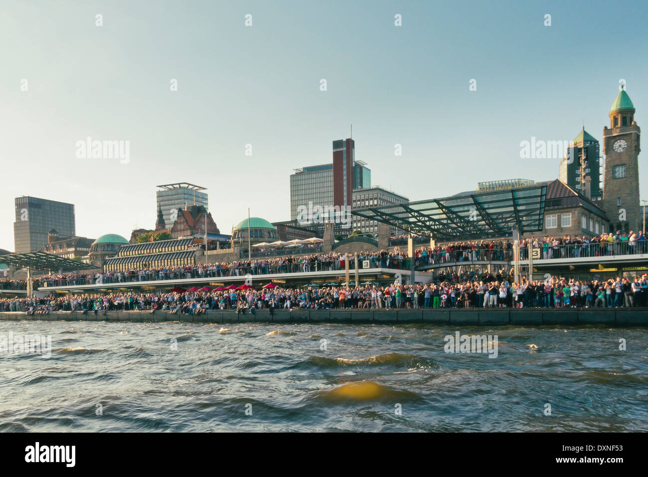 Germany, Hamburg, People at the landing stages watching Queen Mary 2 ...