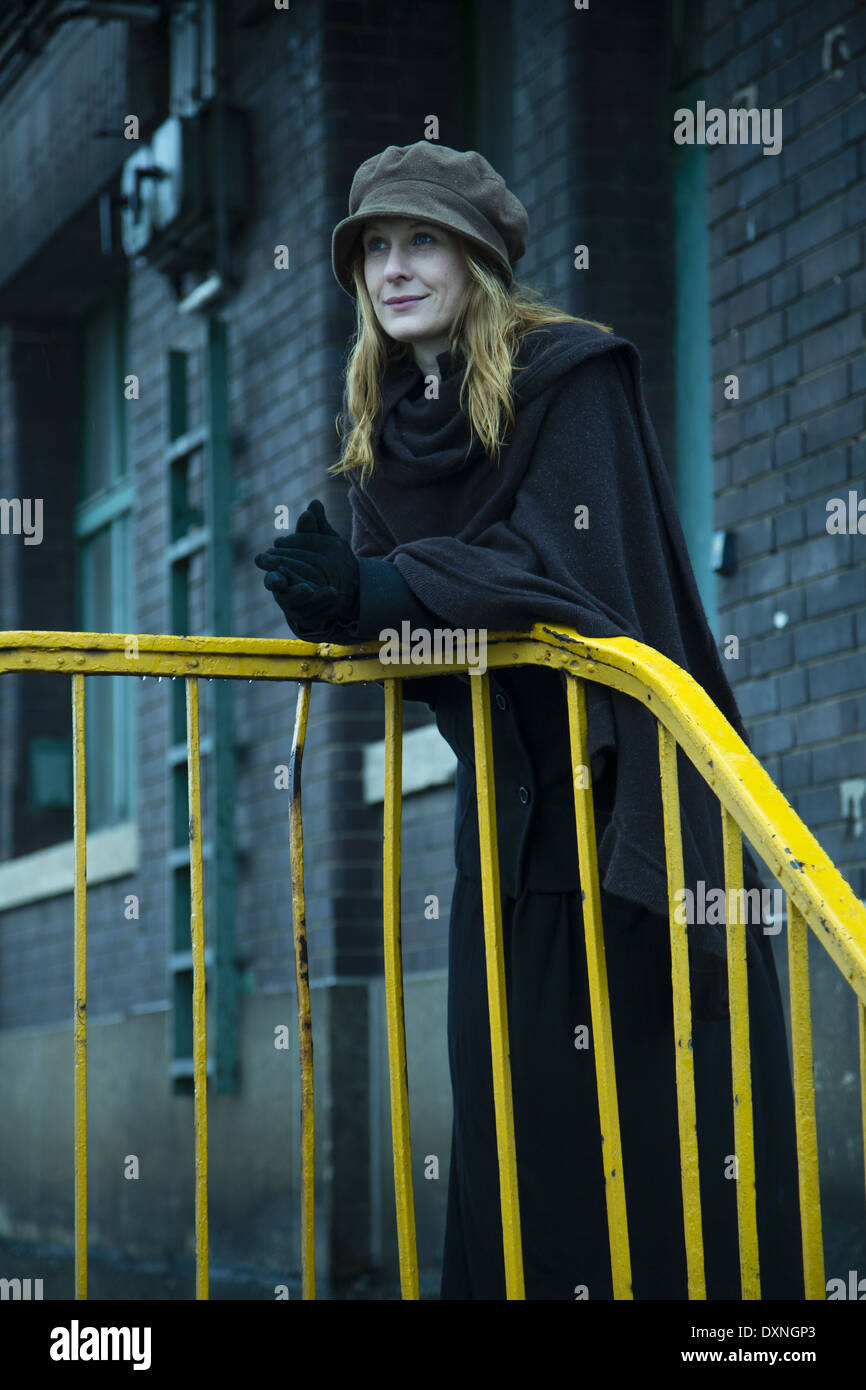 Germany, Berlin, woman leaning on yellow railing Stock Photo - Alamy