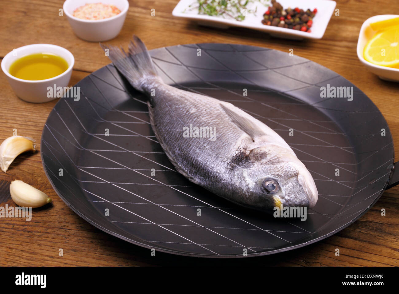 Fresh bream fish on frying pan and ingredients, close up Stock Photo ...