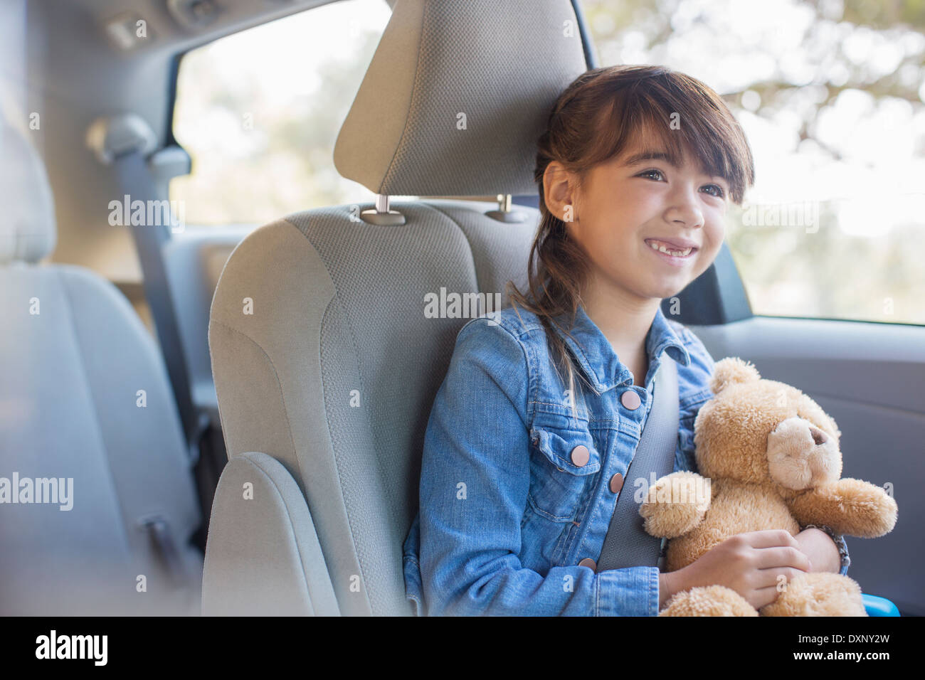 Happy girl with teddy bear in back seat of car Stock Photo - Alamy