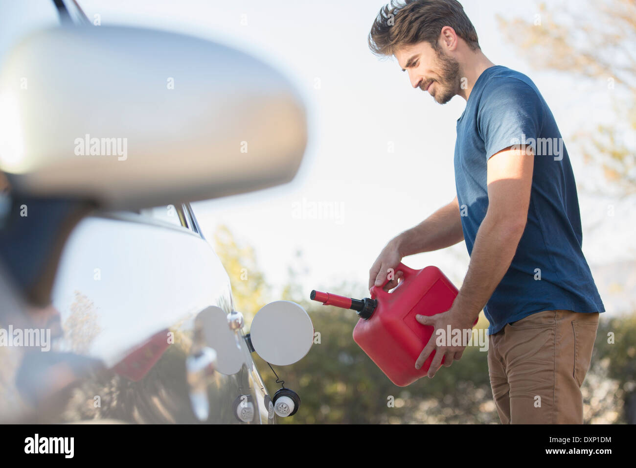 Man filling gas tank at roadside Stock Photo - Alamy