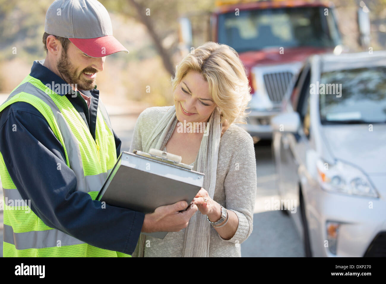 Roadside mechanic and woman reviewing paperwork Stock Photo - Alamy