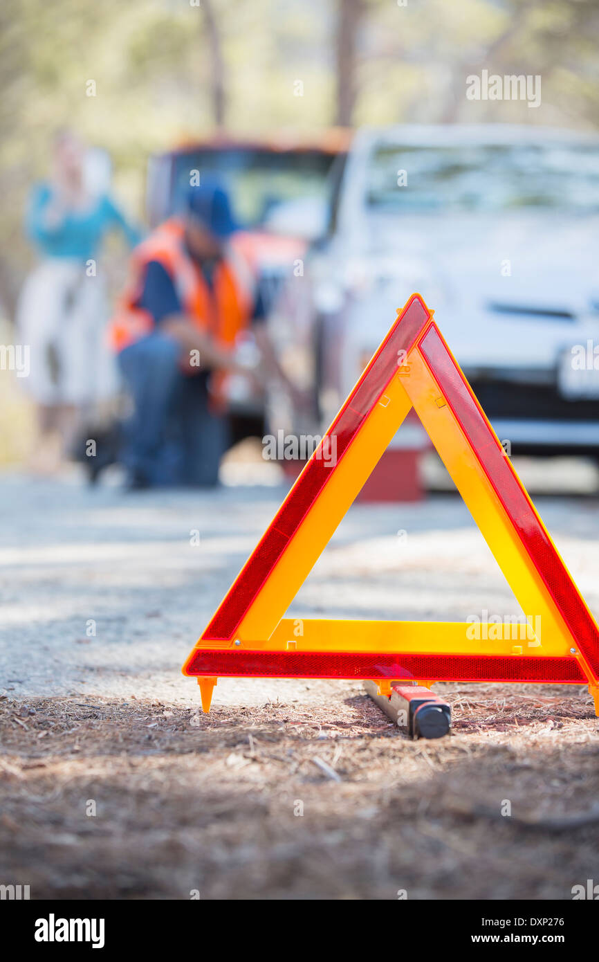 Roadside mechanic helping woman behind warning triangle Stock Photo - Alamy