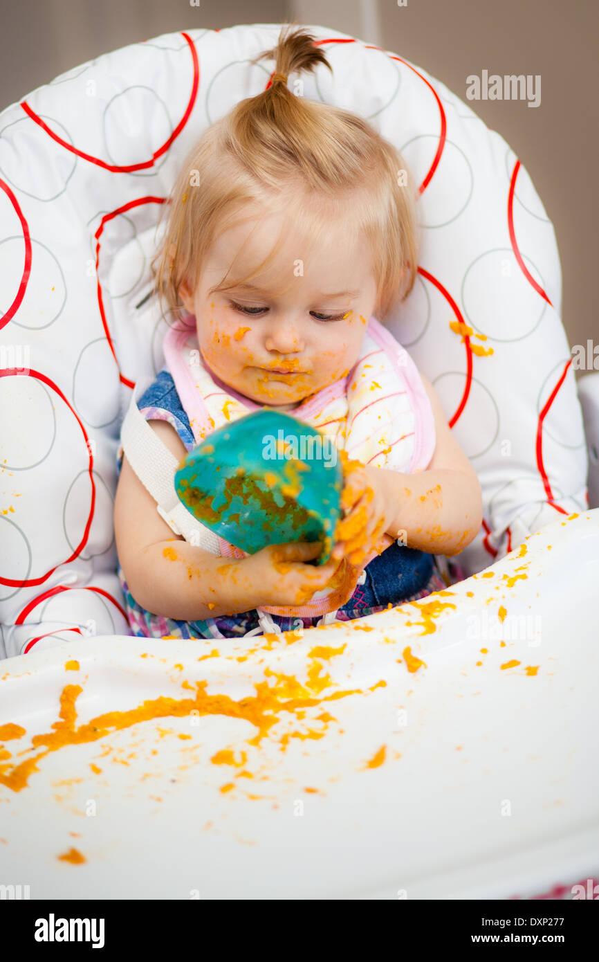 Little baby making a mess with her food Stock Photo - Alamy