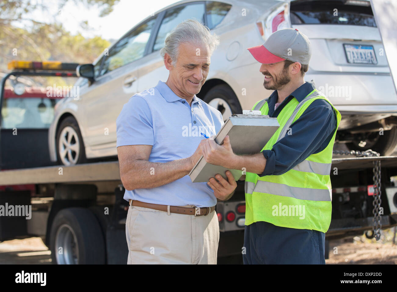 Roadside mechanic and man with paperwork Stock Photo - Alamy