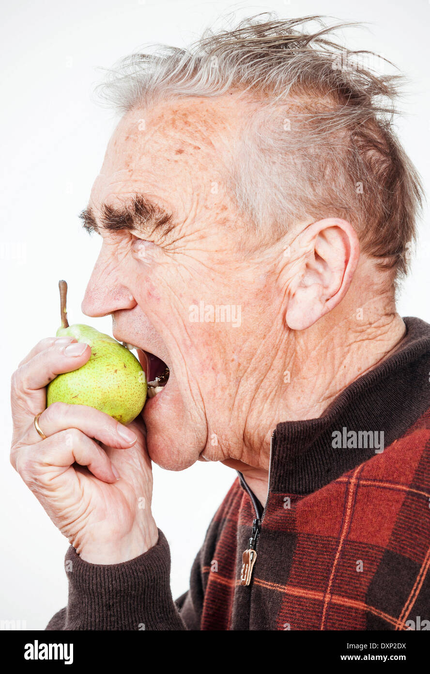 Portrait of senior man eating pear Stock Photo - Alamy