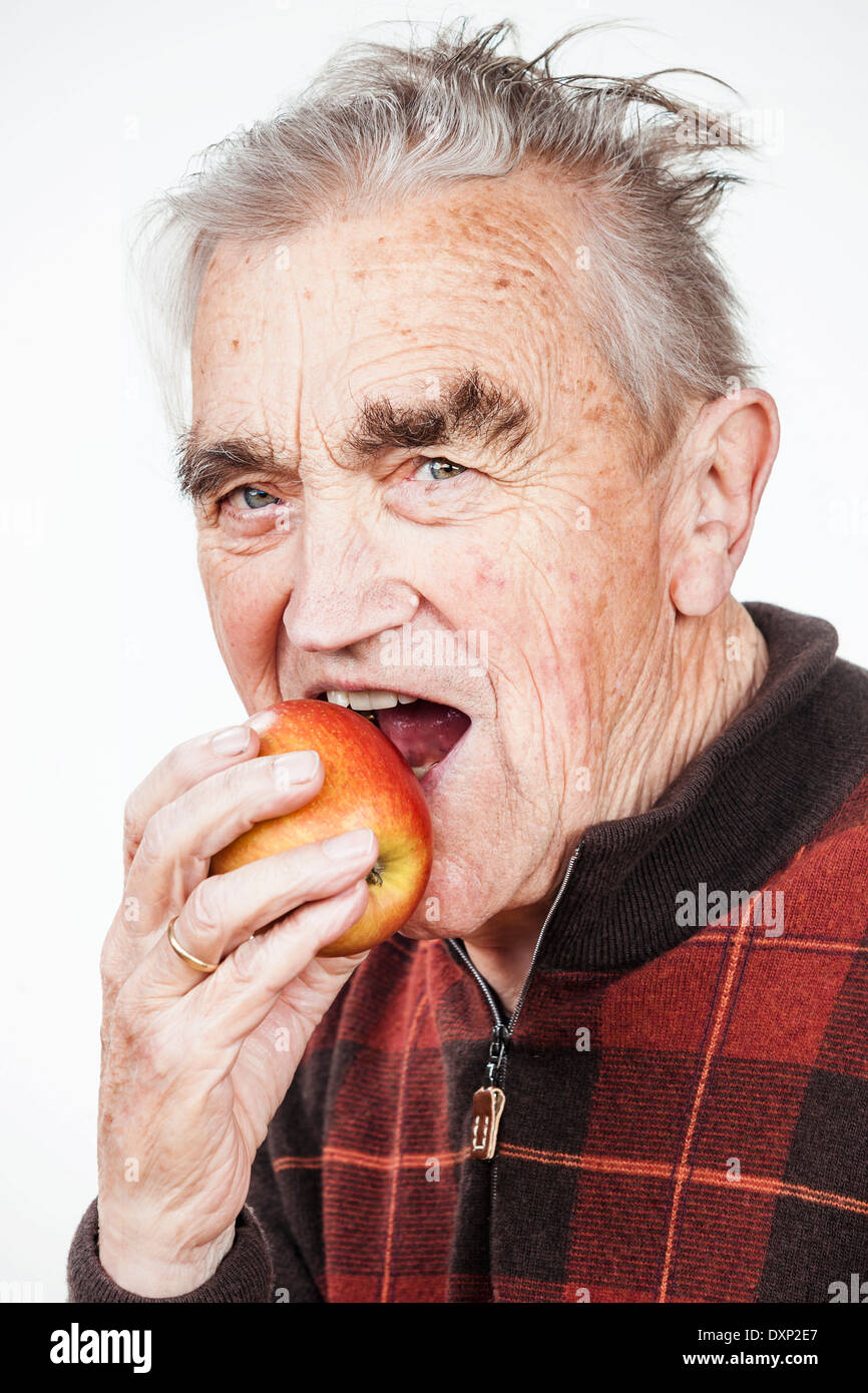 Portrait of senior man eating apple Stock Photo - Alamy