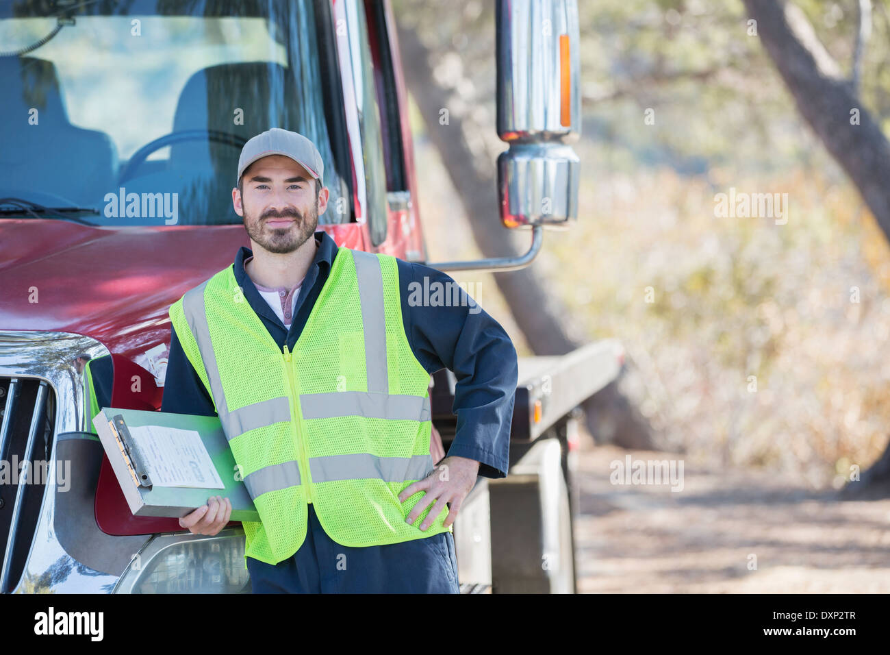 Portrait of confident roadside mechanic leaning on truck Stock Photo ...