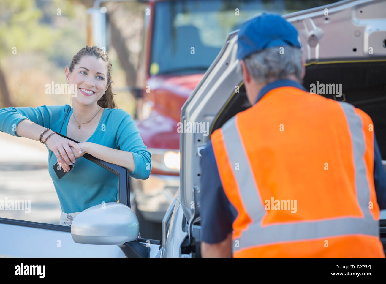 Grateful woman watching roadside mechanic fix car Stock Photo - Alamy
