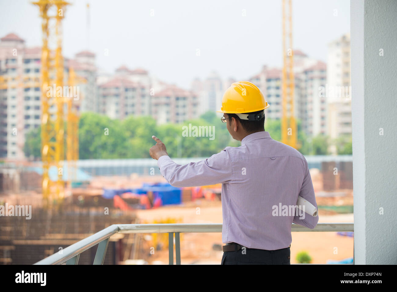 indian male architect inspecting site with construction background ...