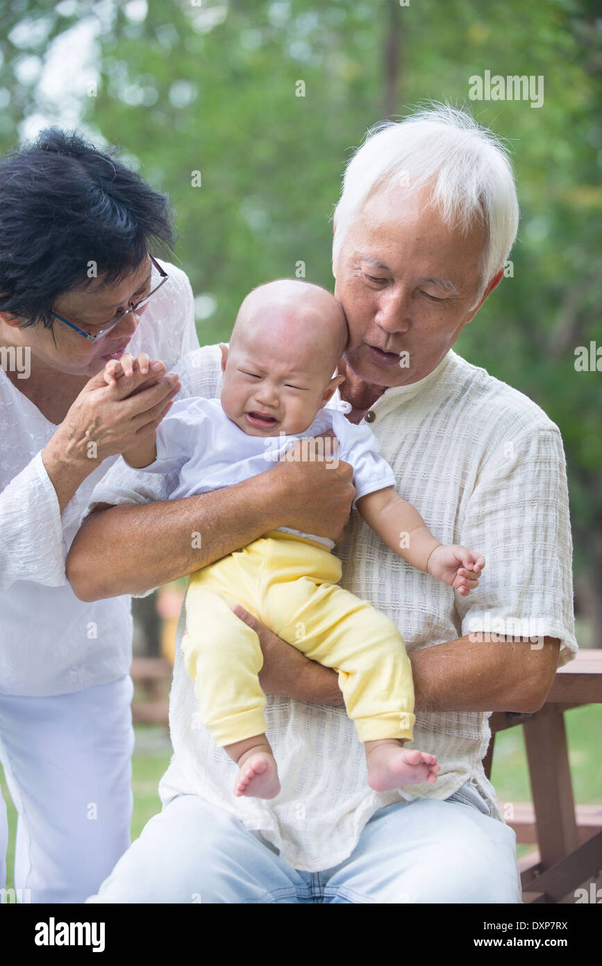 asian baby crying while being comforted by grandparents Stock Photo - Alamy