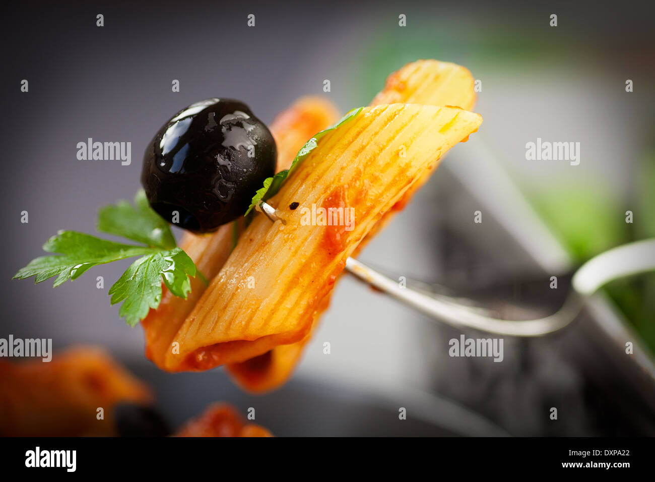 Italian food. Pasta penne with tomato sauce, olives and garnish Stock ...