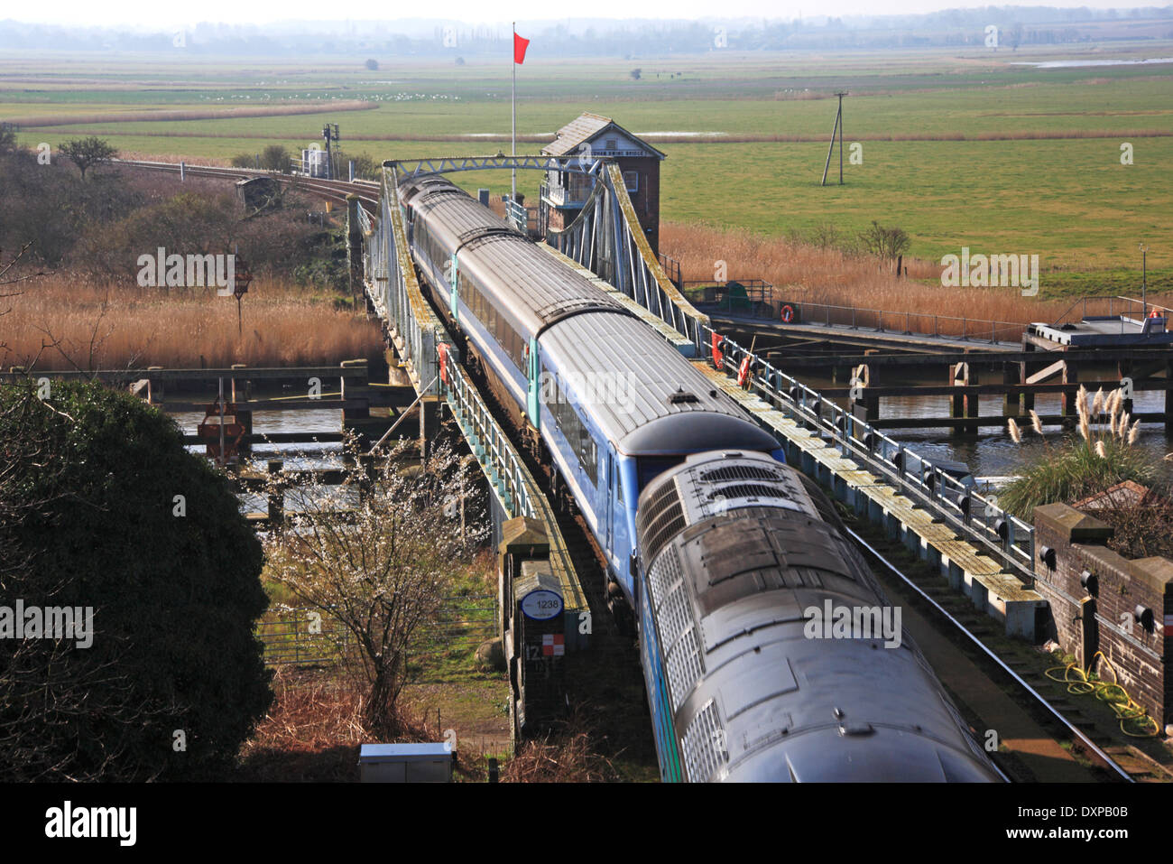 A passenger train crossing the swing bridge over the River Yare at ...