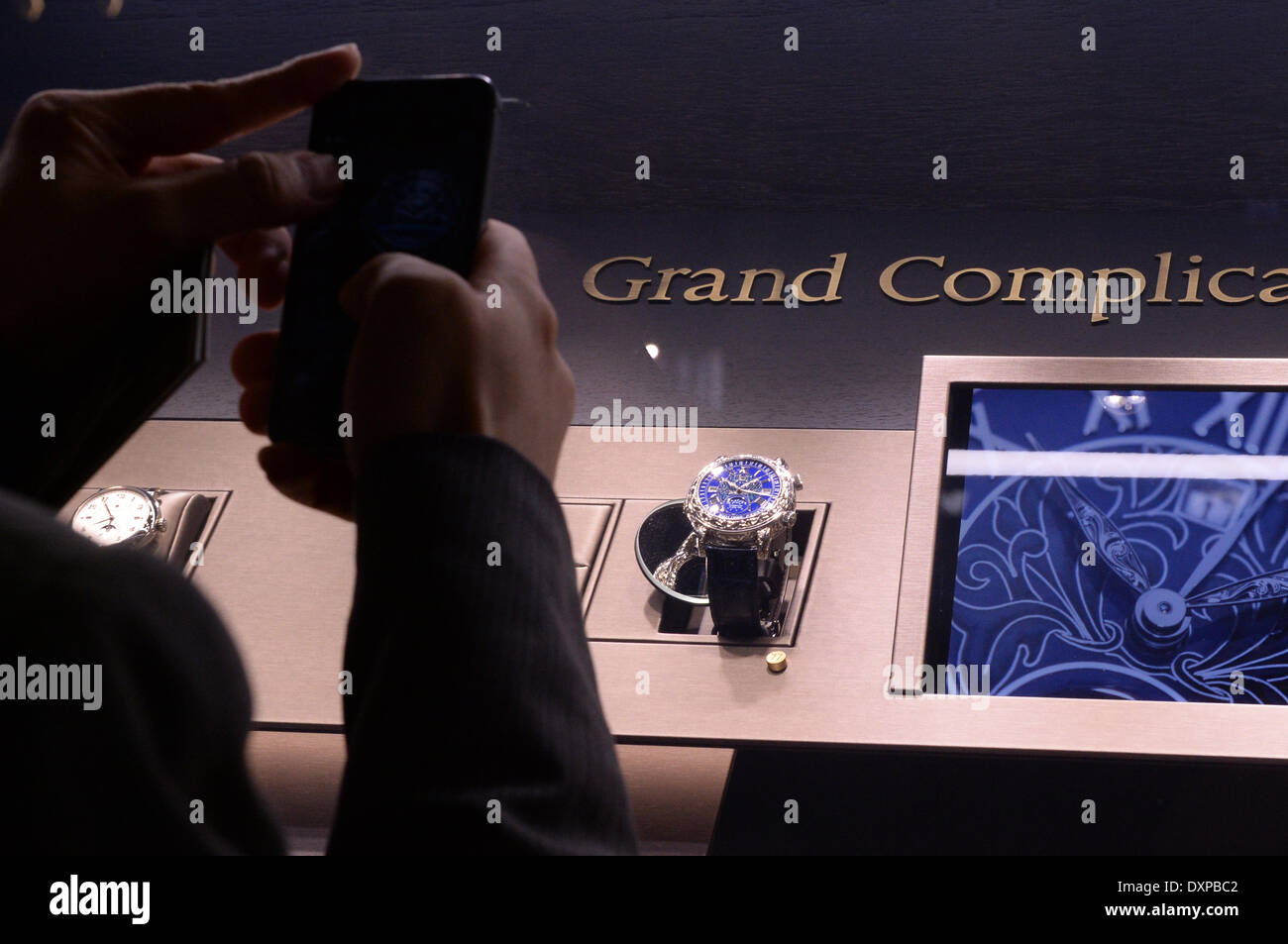 Basel, Switzerland. 28th Mar, 2014. A visitor photographs a watch of ...