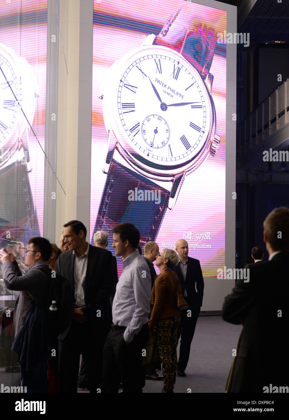 Basel, Switzerland. 28th Mar, 2014. Visitors look at watches of the ...