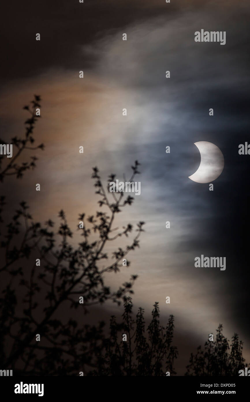 A solar eclipse through a sheet of thin clouds over Alberta, Canada ...