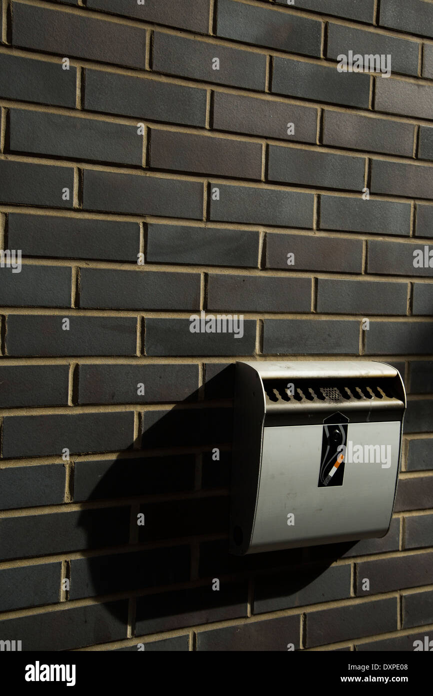 Cigarette Ash Bin mounted on Brick Wall Stock Photo - Alamy