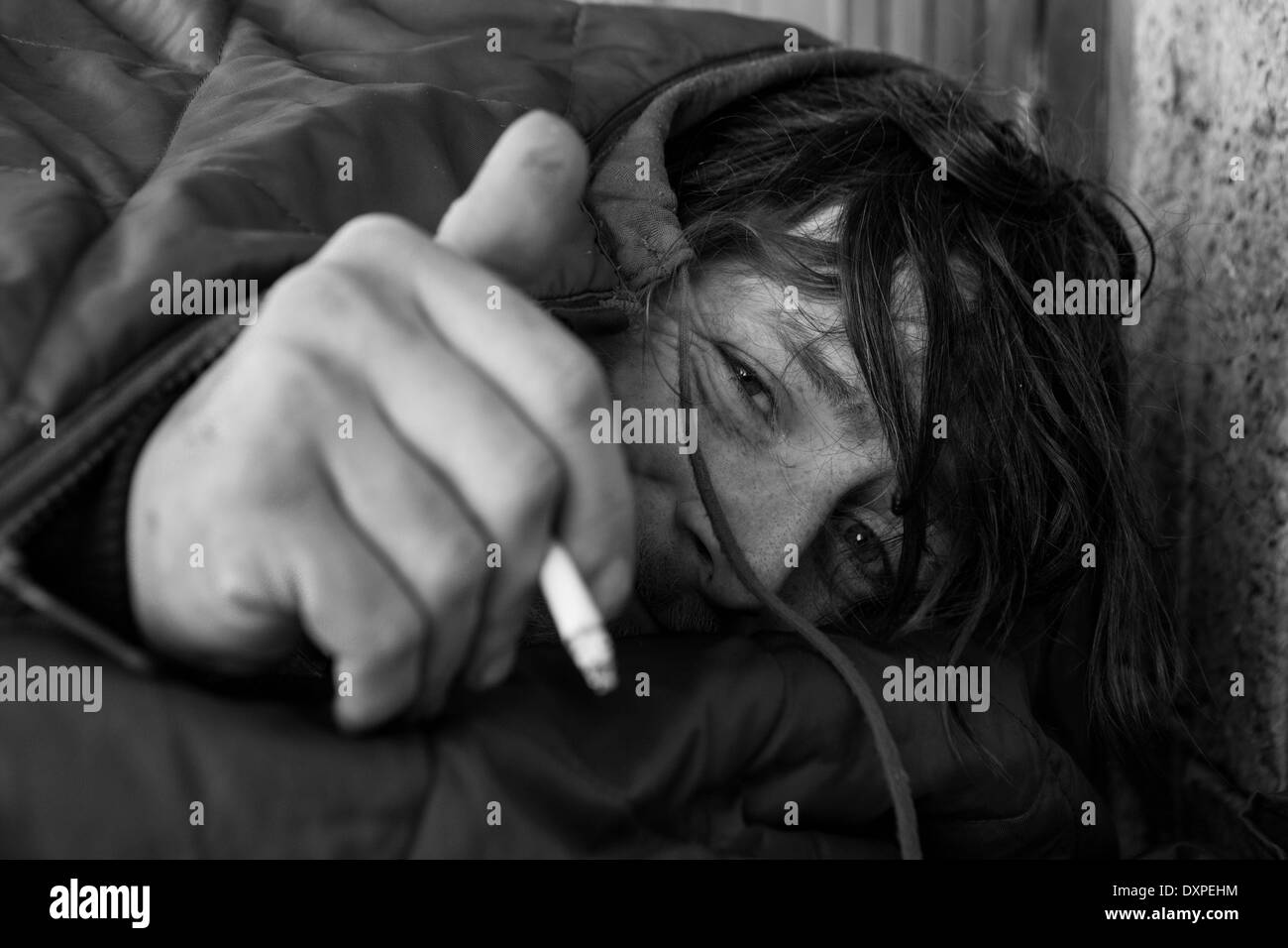 Homeless man smoking cigarette hi-res stock photography and images - Alamy