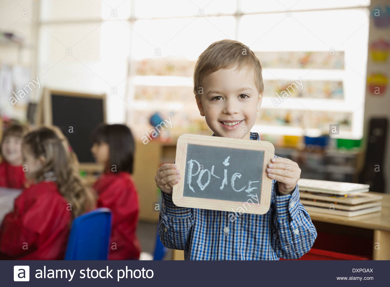Elementary boy holding slate with "Police" written on it Stock Photo ...