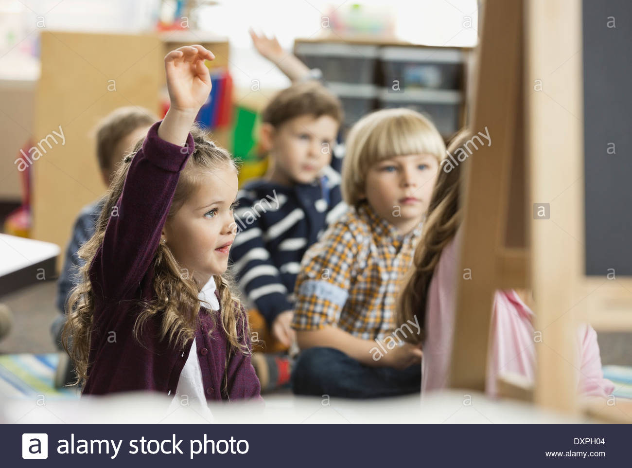 Girl with hand raised in classroom hi-res stock photography and images ...