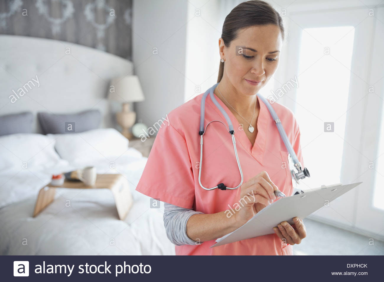 Nurse reading medical report at home Stock Photo - Alamy
