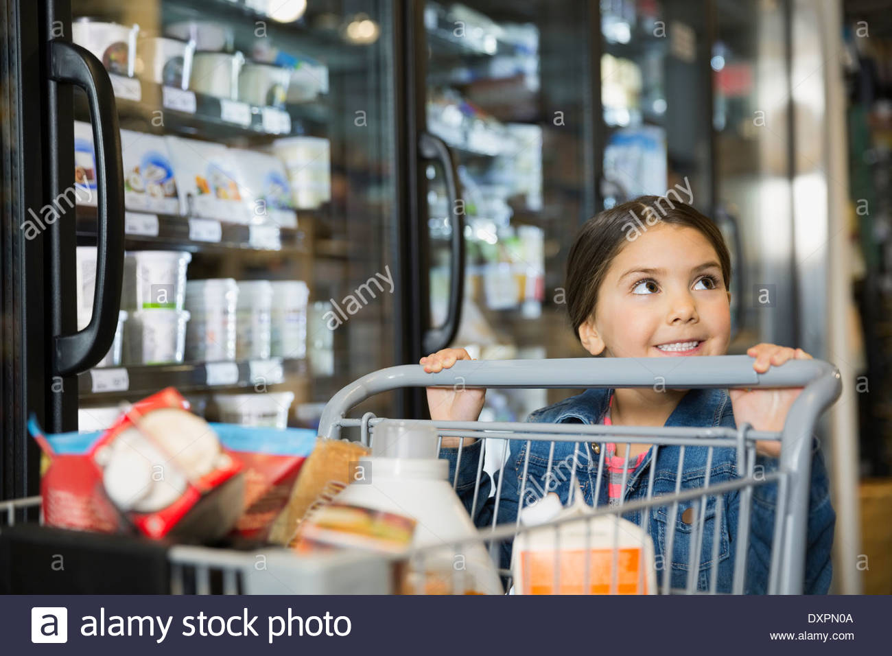 Girl pushing shopping cart in market Stock Photo - Alamy