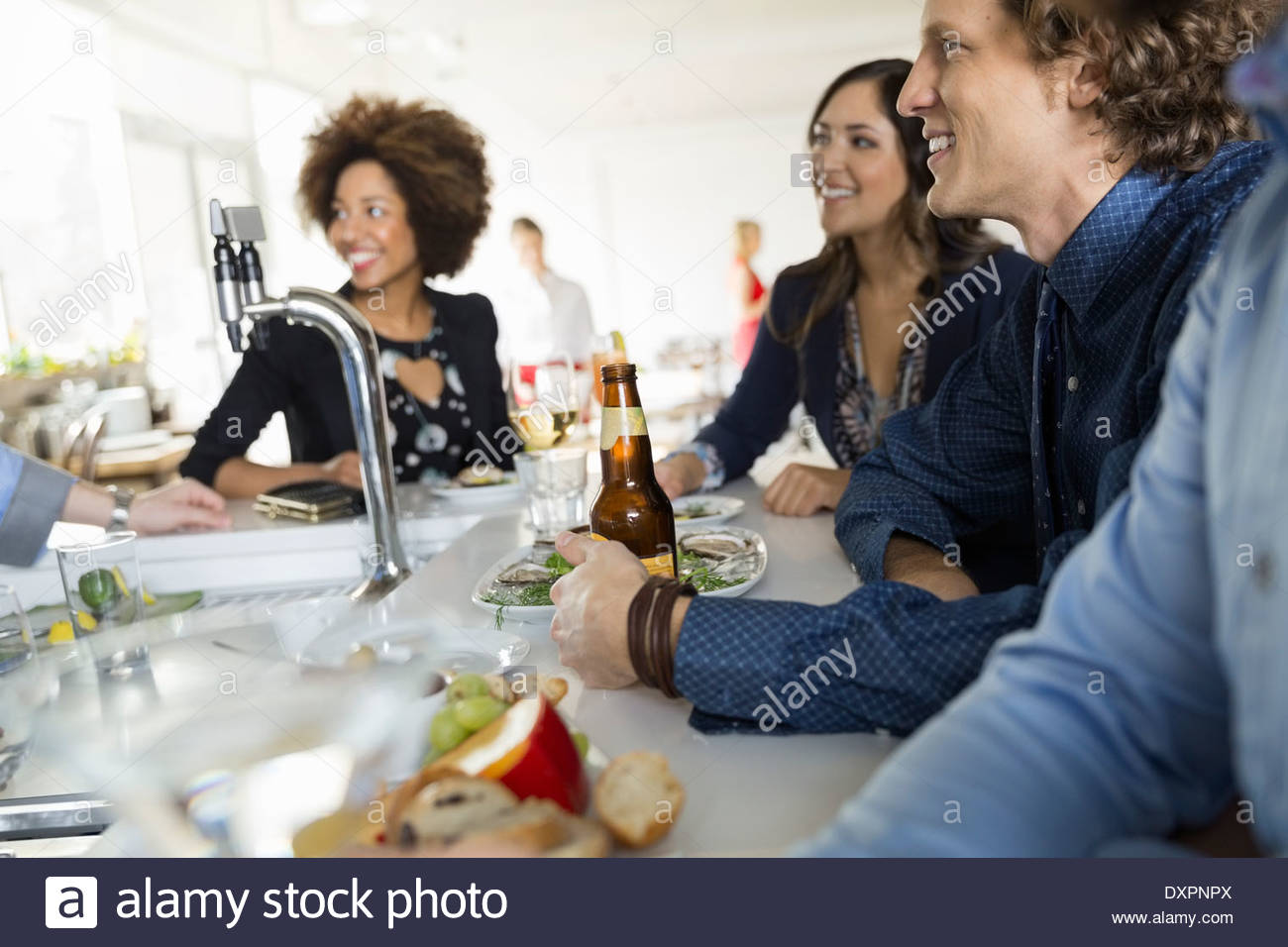 Friends eating and drinking at bar Stock Photo - Alamy