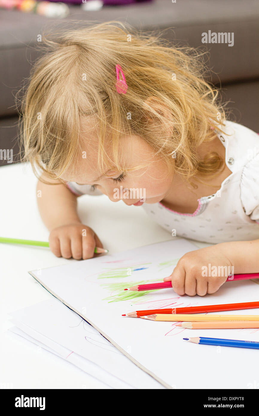 Little girl drawing with colorful crayons at home Stock Photo - Alamy