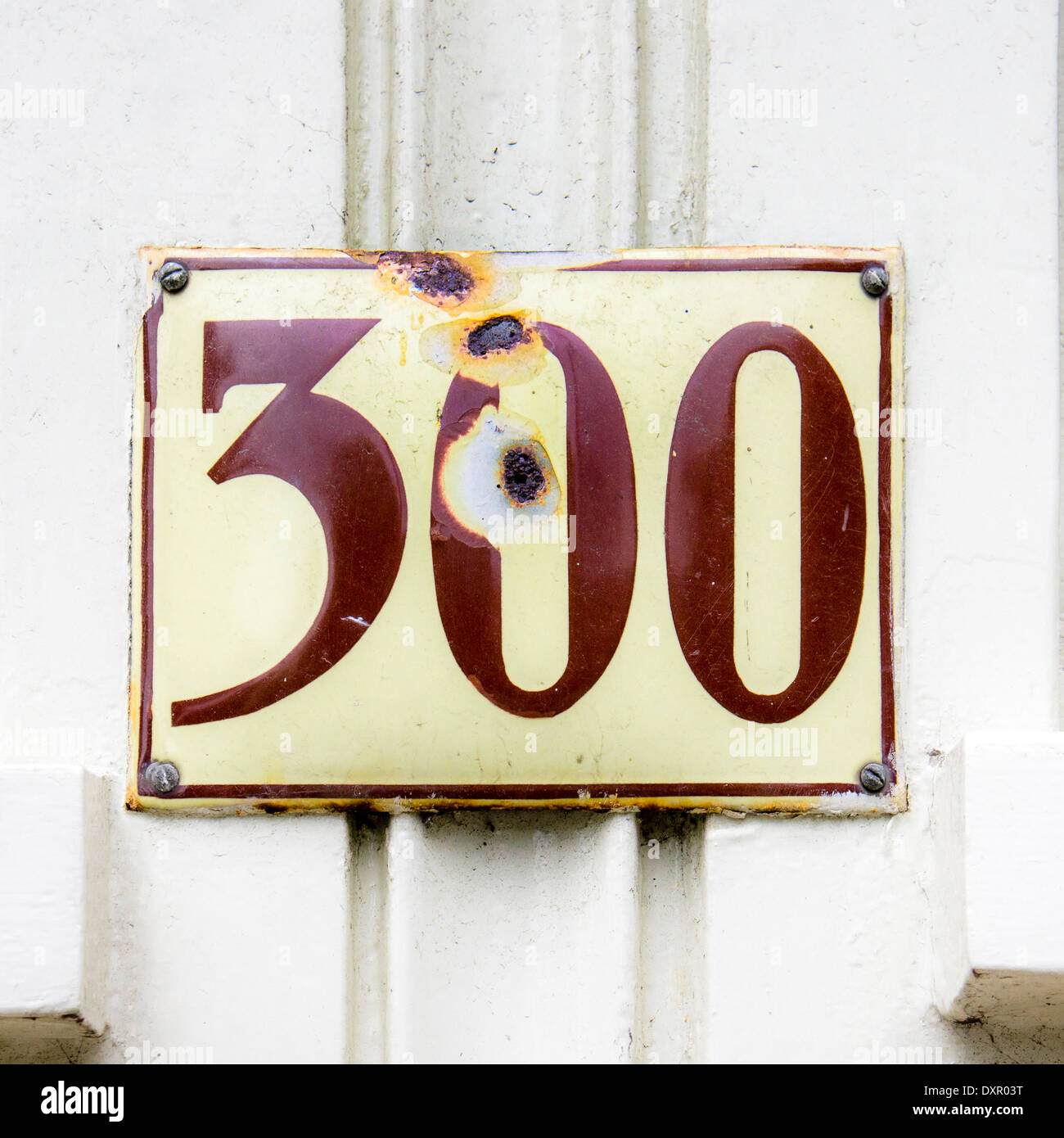 House number three hundred. Brown lettering on a yellowish enameled ...