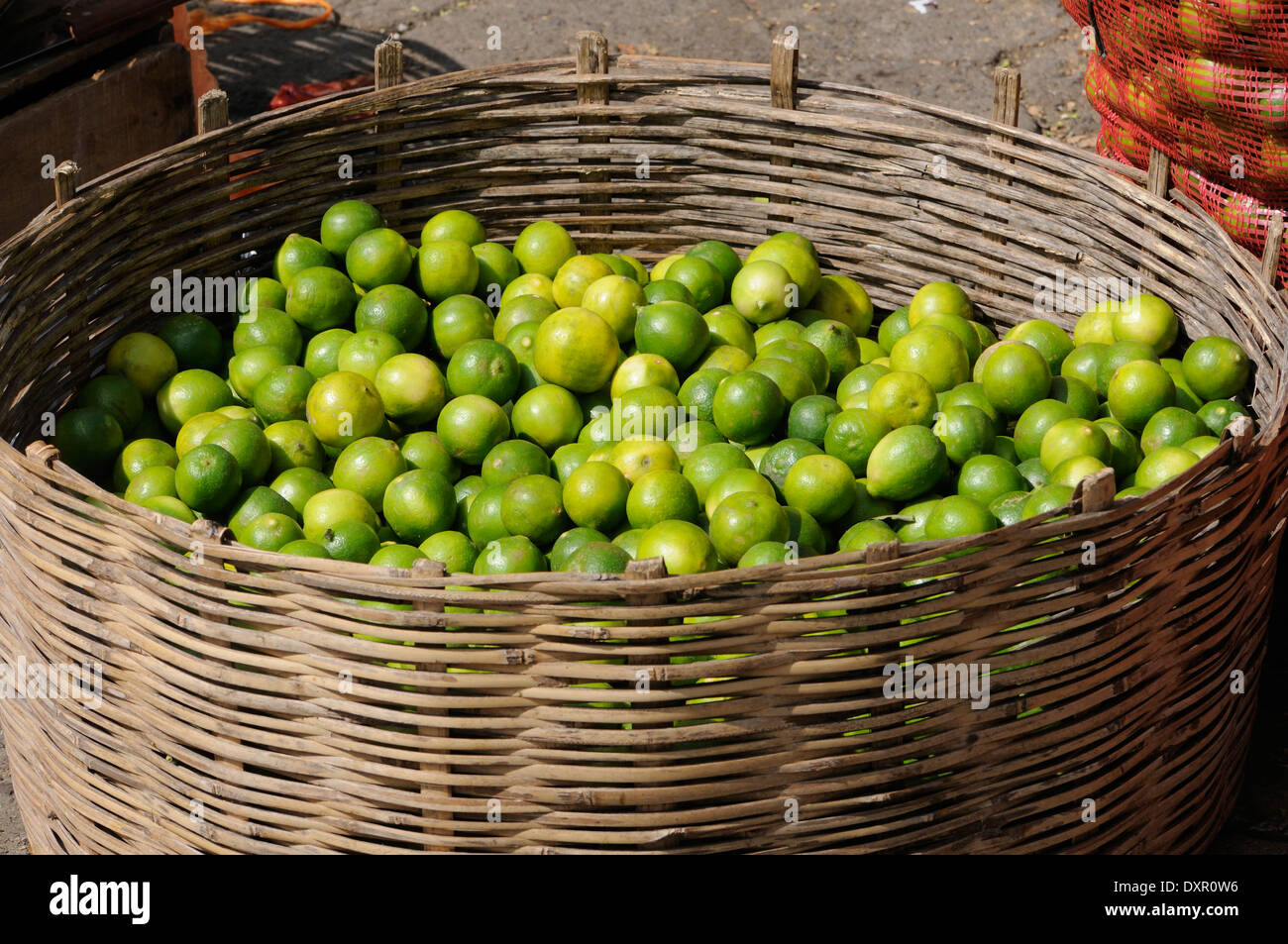 Basket of small green citrus fruit for sale in the vegetable market in ...