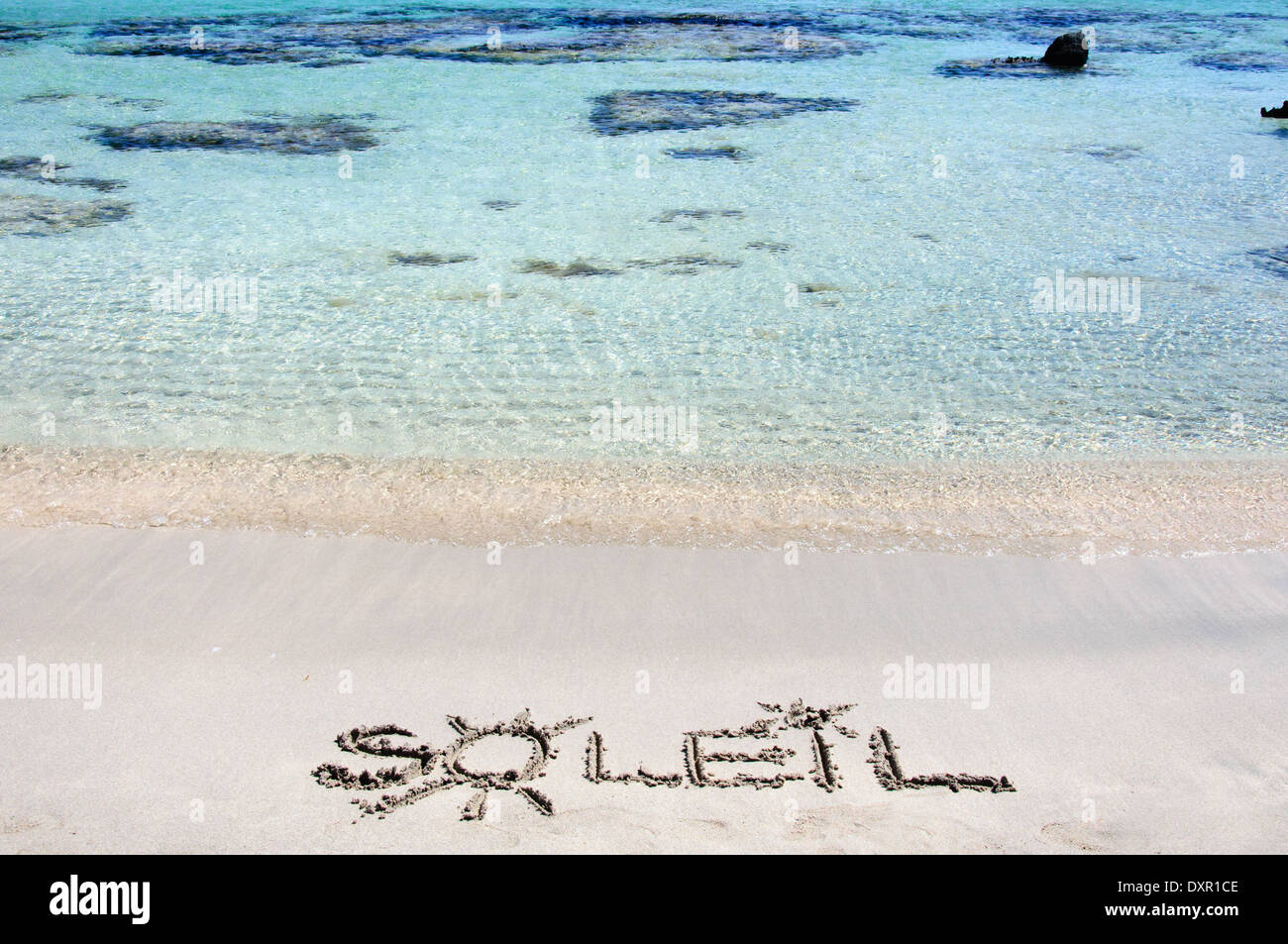 The Word "SOLEIL" Written on Sand on a beautiful beach, with blue waves ...