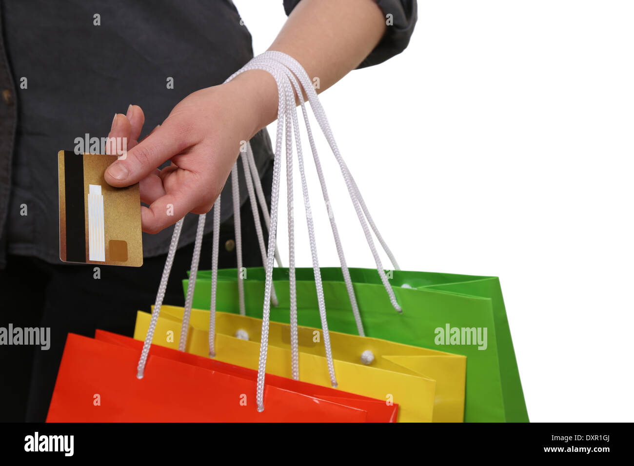 Young woman with shopping bags paying her purchase with credit card ...