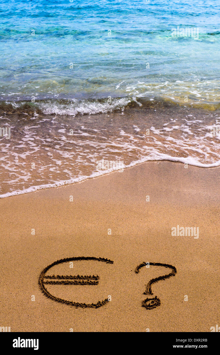 Euro sign and question mark in the sand, with blue sea water in ...